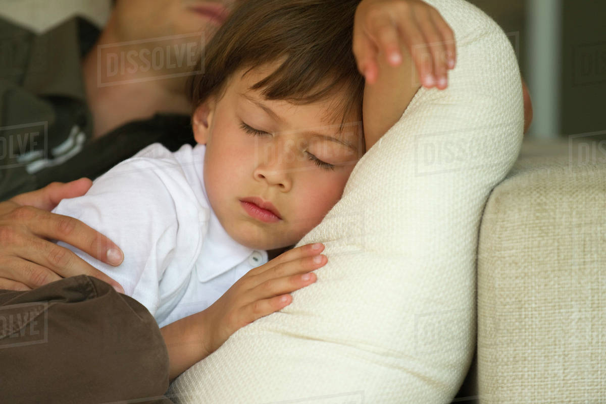 Boy napping on sofa with his father, cropped - Royalty-free Stock Photo ...