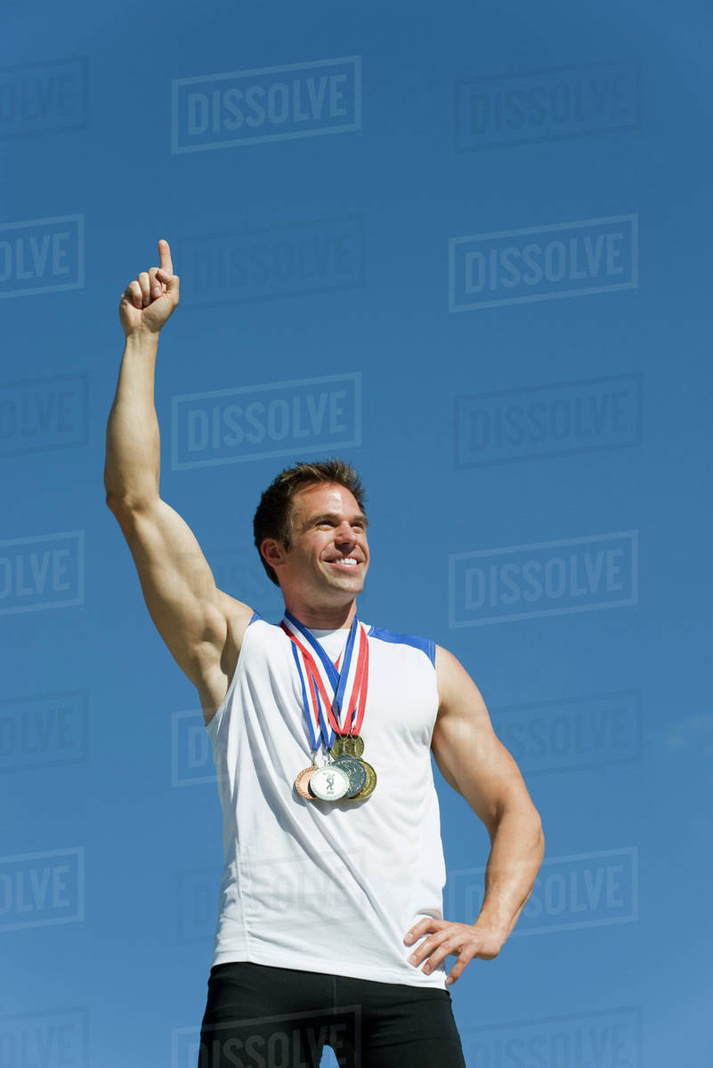 Male athlete with hand raised in victory - Royalty-free Stock Photo ...