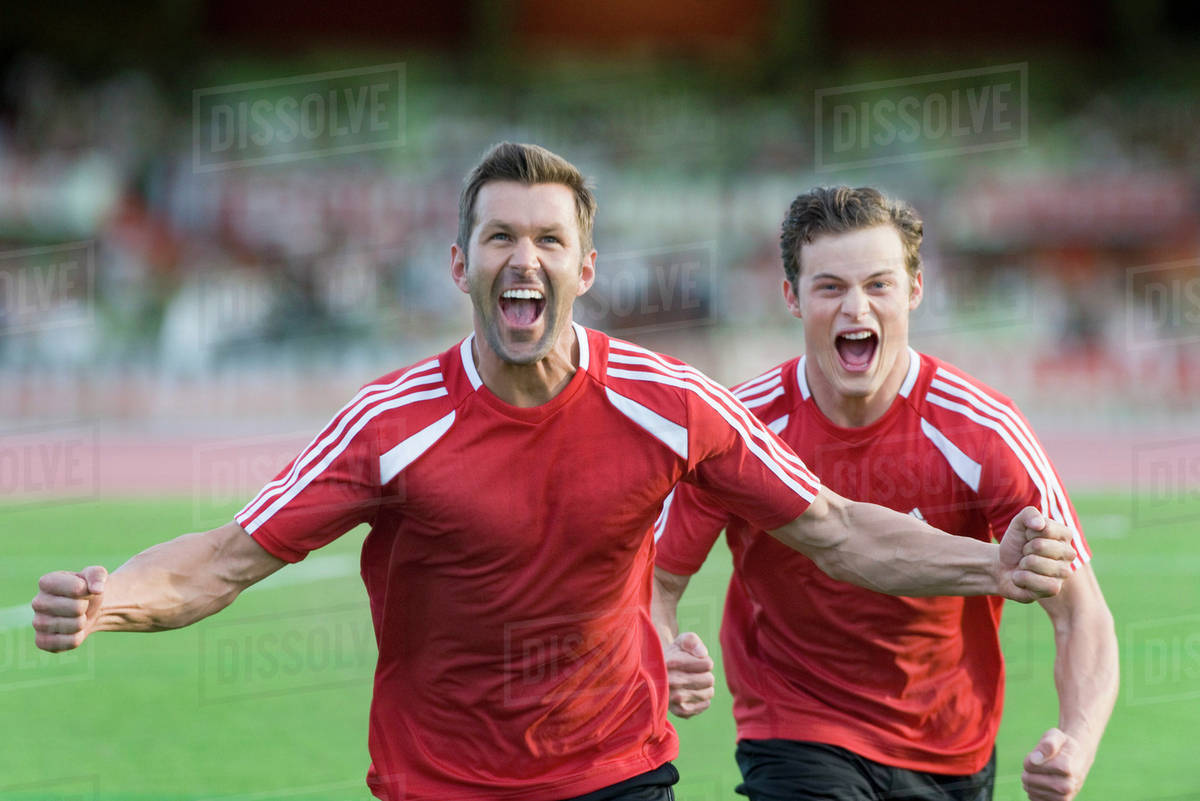 Soccer players shouting in victory - Stock Photo - Dissolve