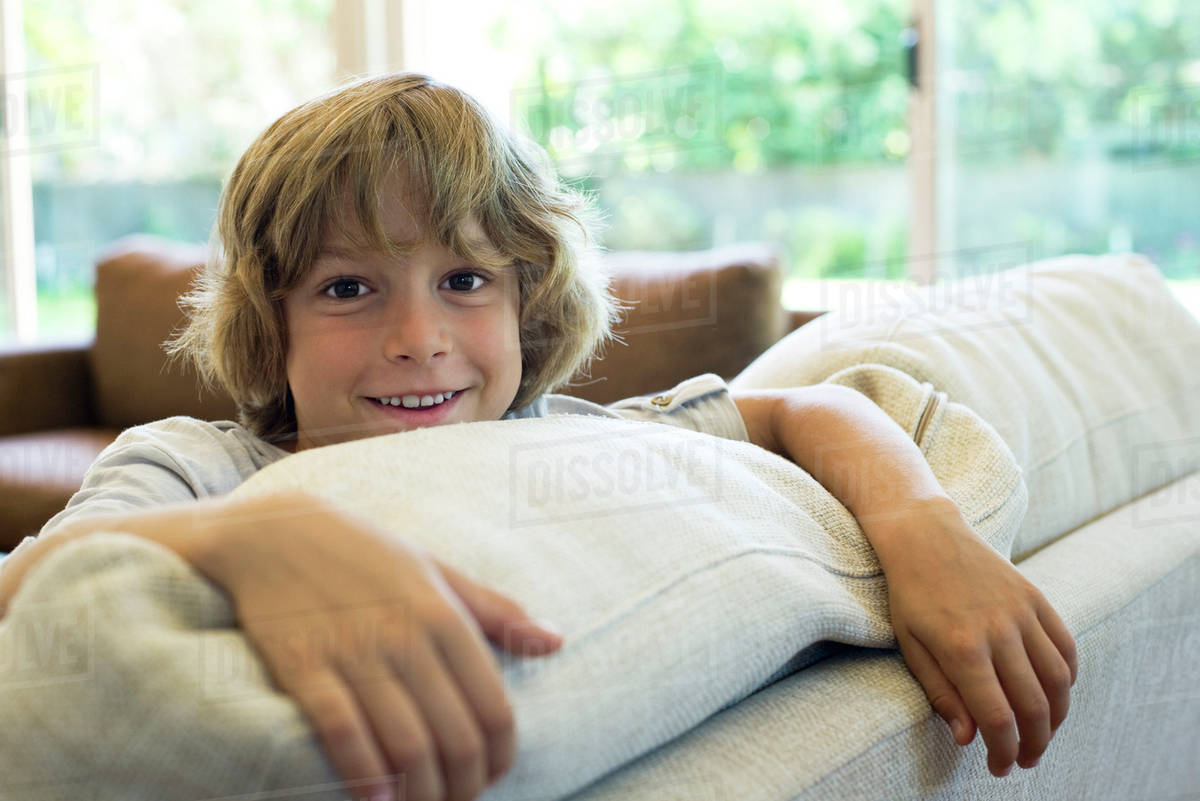Boy leaning on sofa - Royalty-free Stock Photo | Dissolve