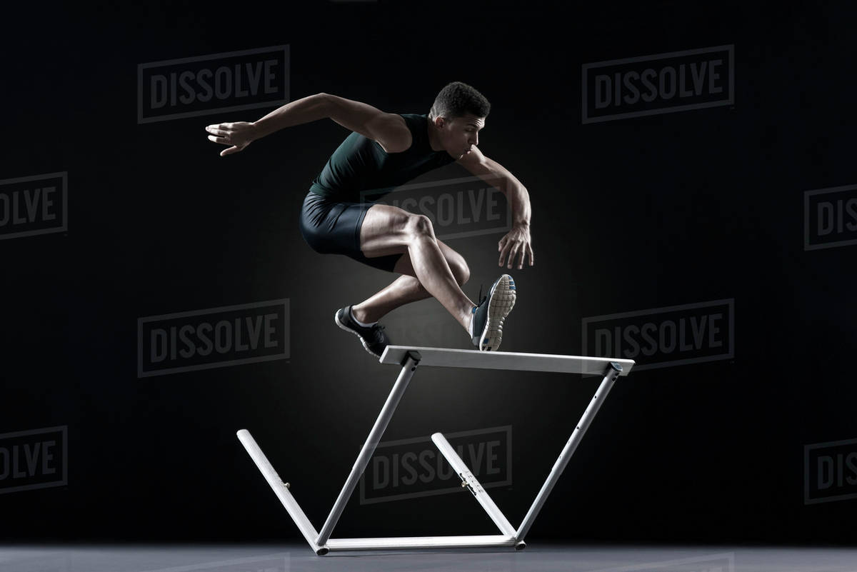 Male athlete clearing hurdle - Royalty-free Stock Photo | Dissolve
