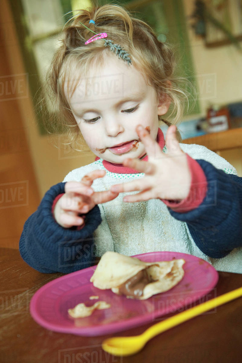 Toddler playing with hands while eating snack - Royalty-free Stock ...