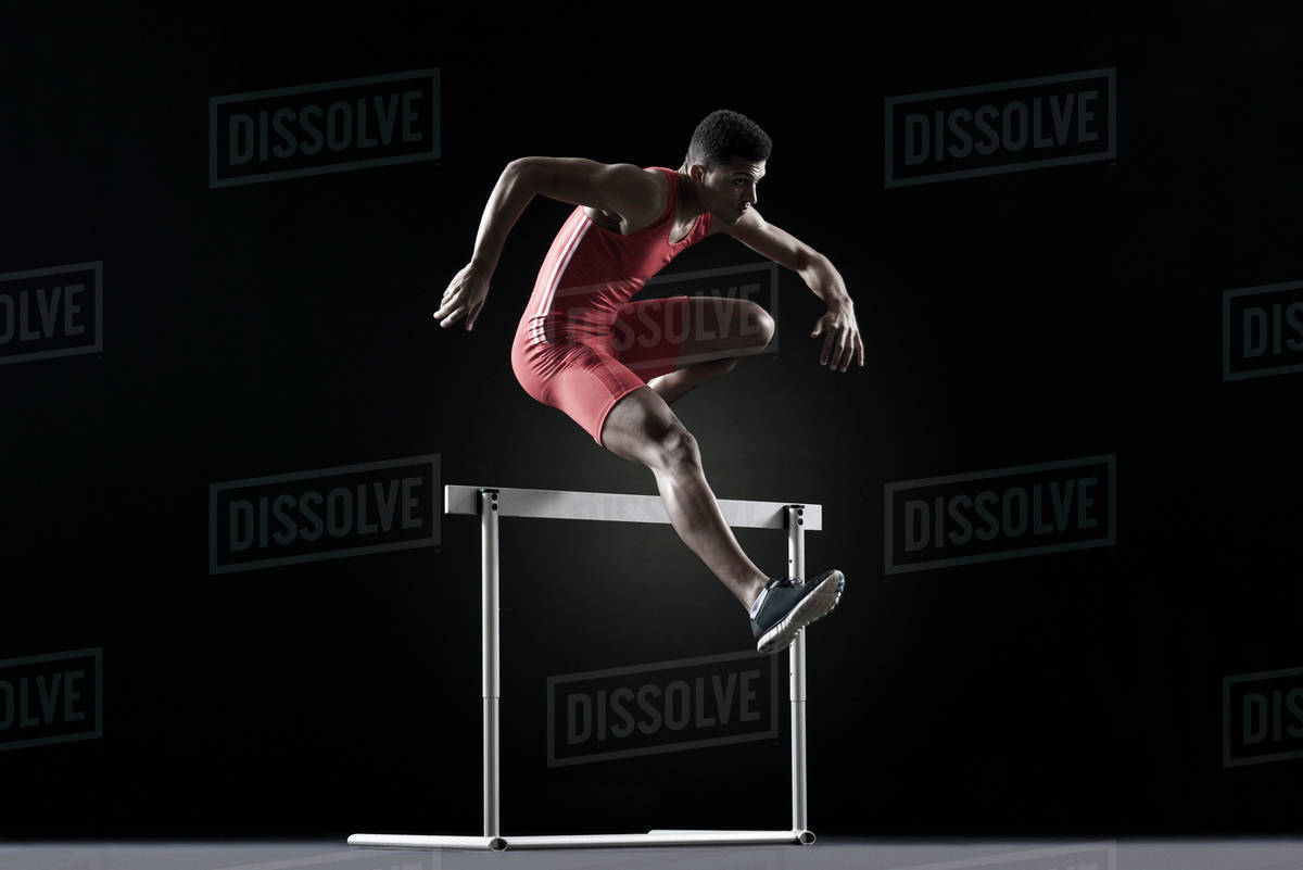 Male athlete cearling hurdle - Royalty-free Stock Photo | Dissolve