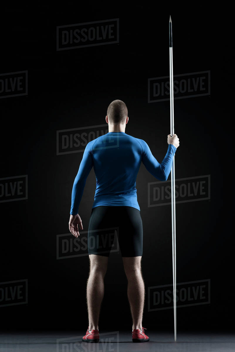 Male athlete standing with javelin, rear view - Royalty-free Stock ...