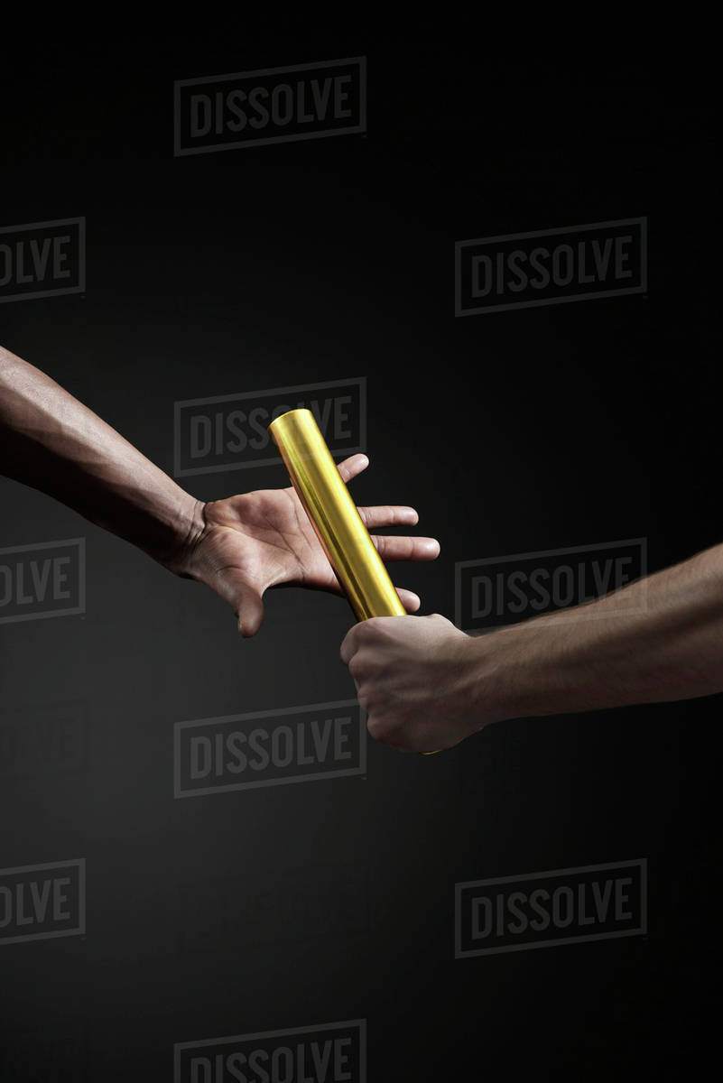 Runners passing baton, cropped - Stock Photo - Dissolve