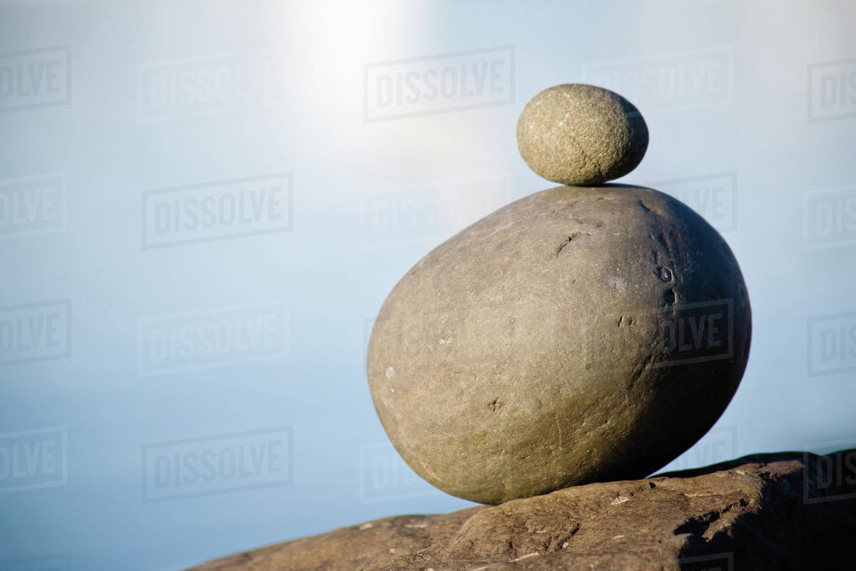 Small stone stacked on top of larger stone - Stock Photo - Dissolve