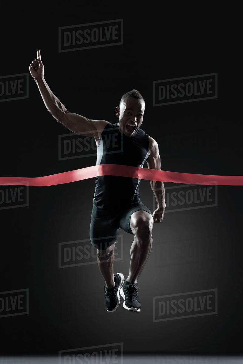 Runner crossing finish line - Stock Photo - Dissolve