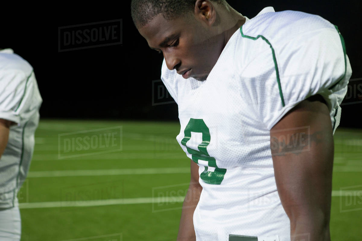 Football player looking down in disappointment - Royalty-free Stock ...