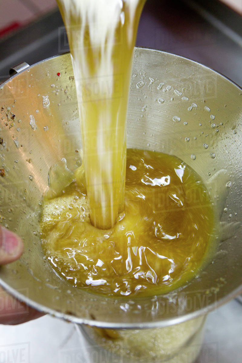 Pouring oil through funnel - Stock Photo - Dissolve