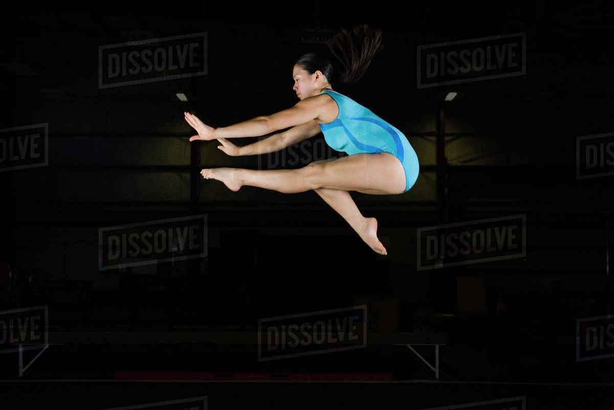 Teenage girl gymnast jumping on balance beam - Royalty-free Stock Photo ...