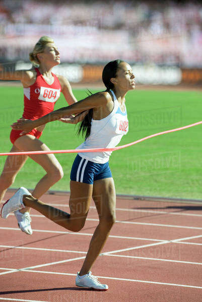 Female runner crossing finish line - Royalty-free Stock Photo | Dissolve