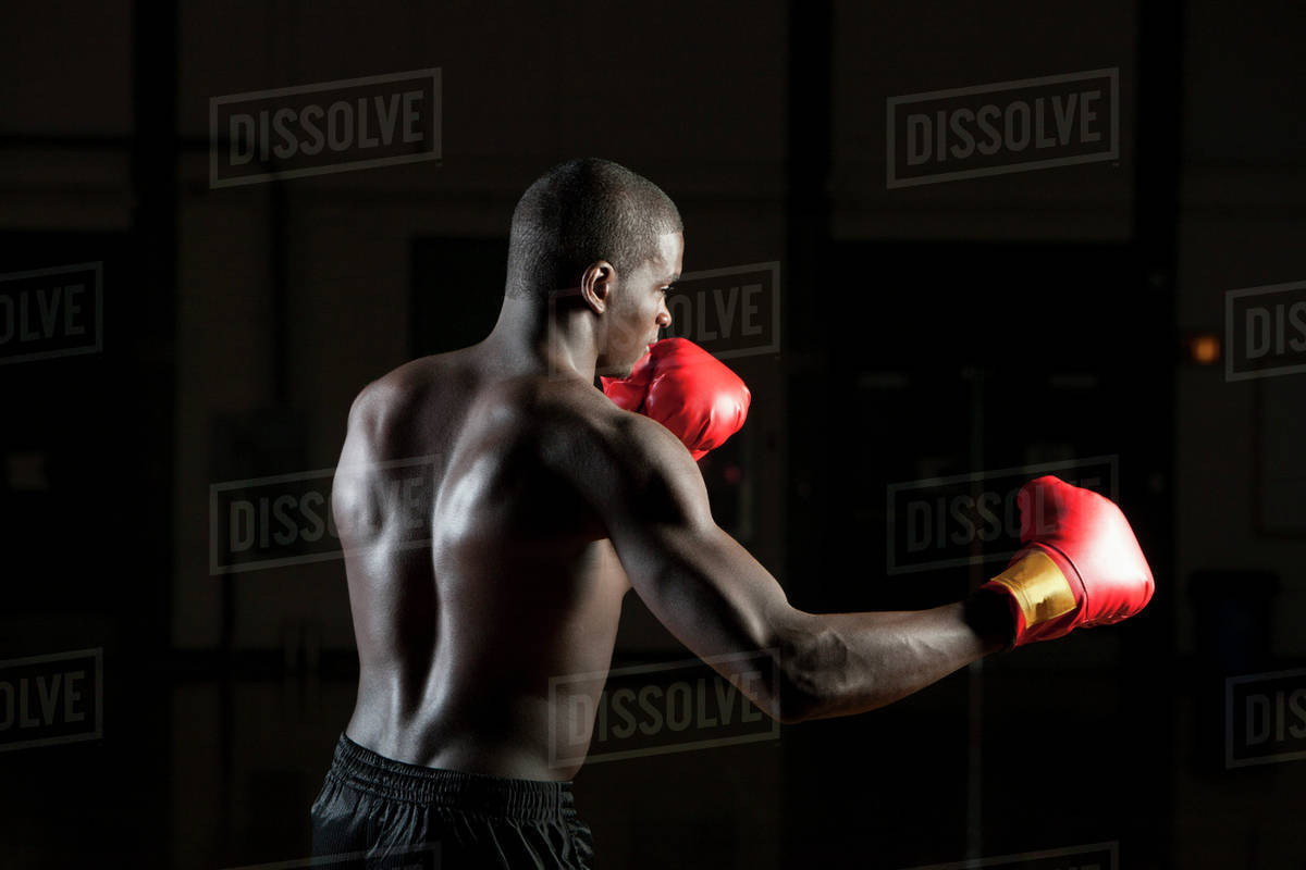 Boxer punching the air, side view - Royalty-free Stock Photo | Dissolve