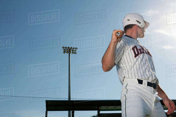 Baseball player holding bat, looking over shoulder - Royalty-free Stock ...