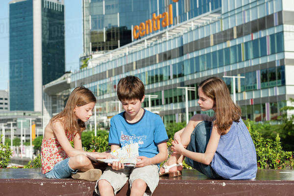 Children reading map in city - Royalty-free Stock Photo | Dissolve