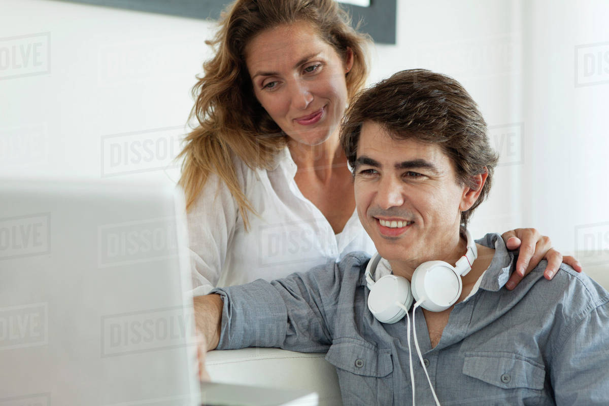Couple looking at laptop computer - Stock Photo - Dissolve
