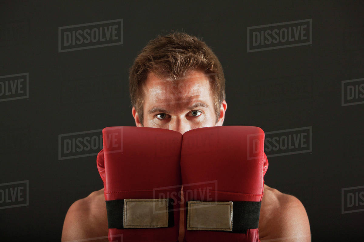 Boxer holding up gloves in front of face in defensive position ...