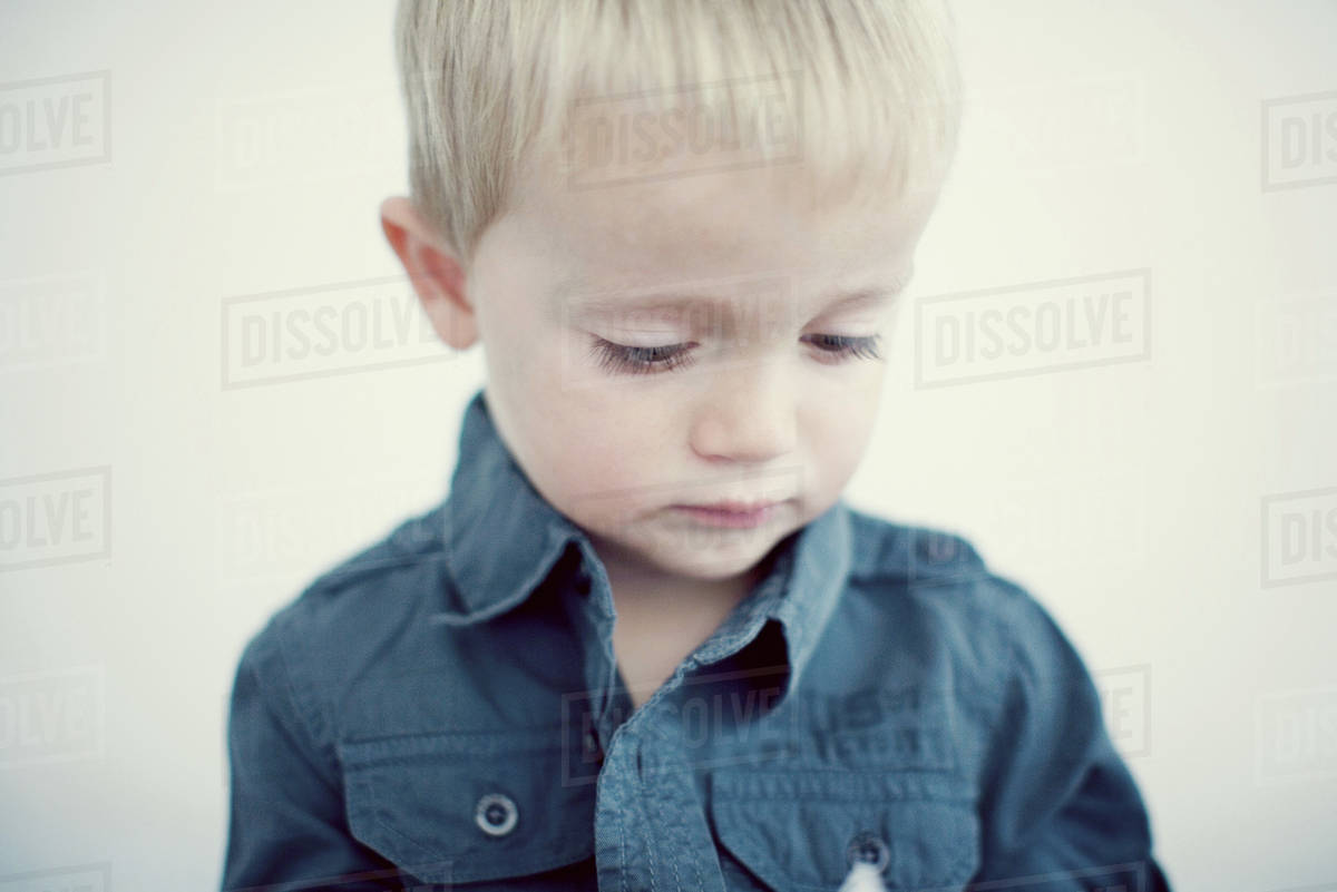 Little boy looking down, portrait - Royalty-free Stock Photo | Dissolve