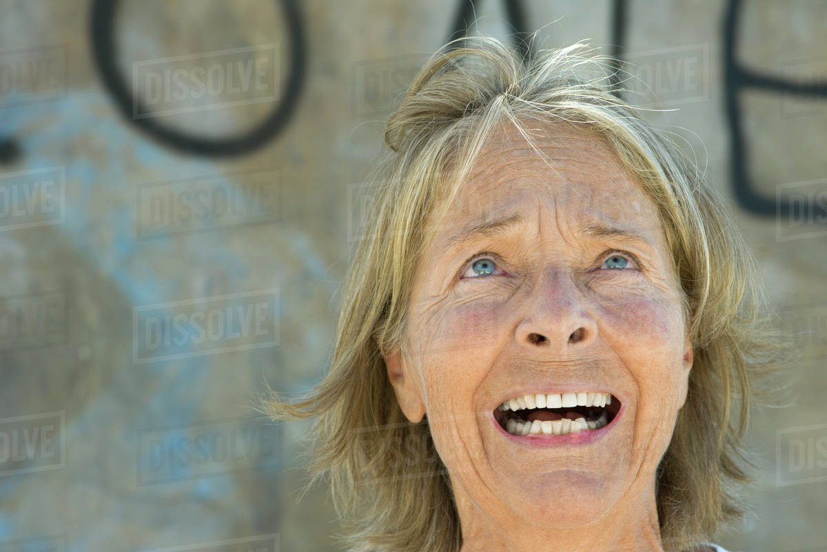 Senior woman looking up with fearful expression on face - Royalty-free ...