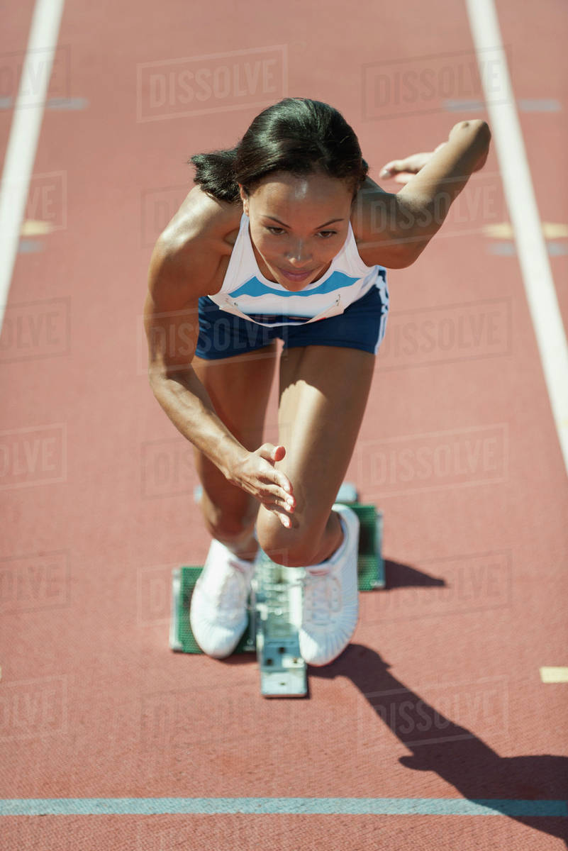 Woman running at starting line - Stock Photo - Dissolve