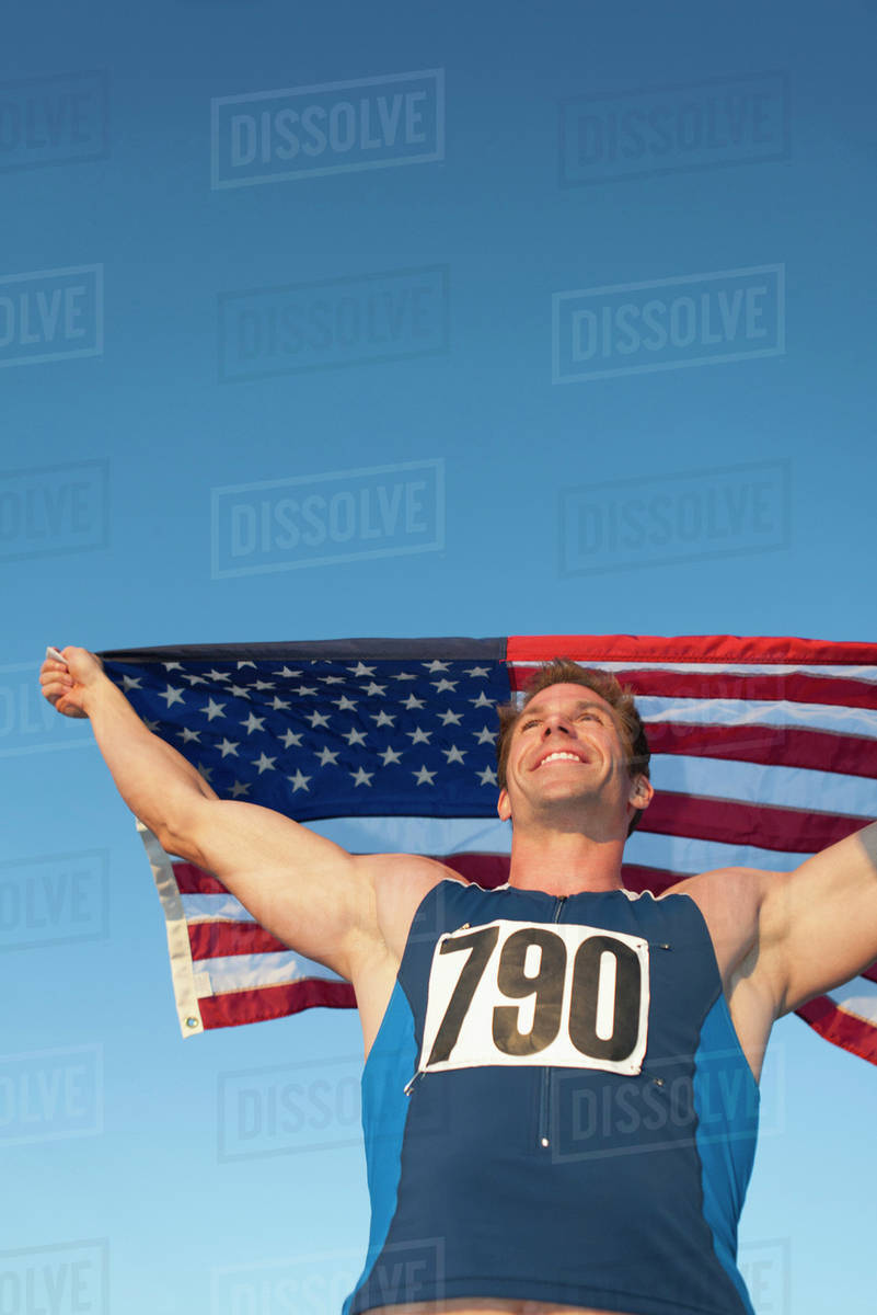 Male athlete holding up American flag - Royalty-free Stock Photo | Dissolve
