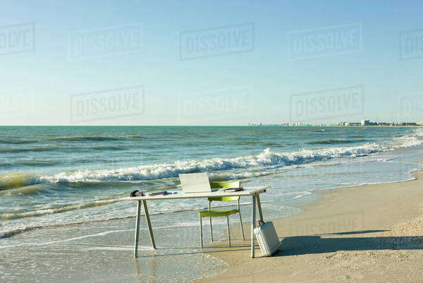 Desk and laptop computer on beach - Royalty-free Stock Photo | Dissolve