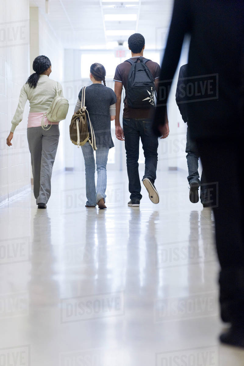 High school students walking down school corridor, rear view - Royalty ...
