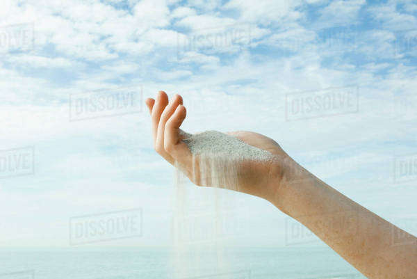 Sand spilling from cupped hand - Royalty-free Stock Photo | Dissolve