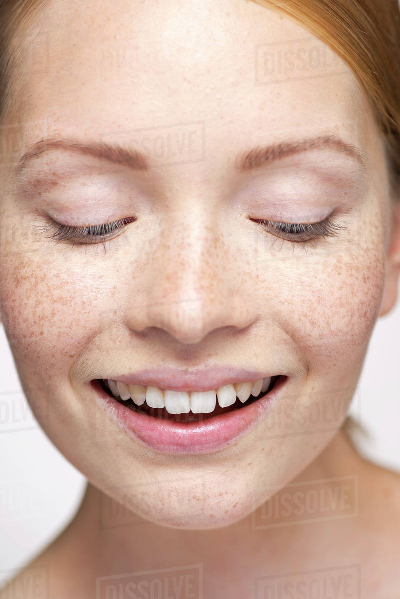 Young woman looking down, smiling, close-up portrait - Royalty-free ...