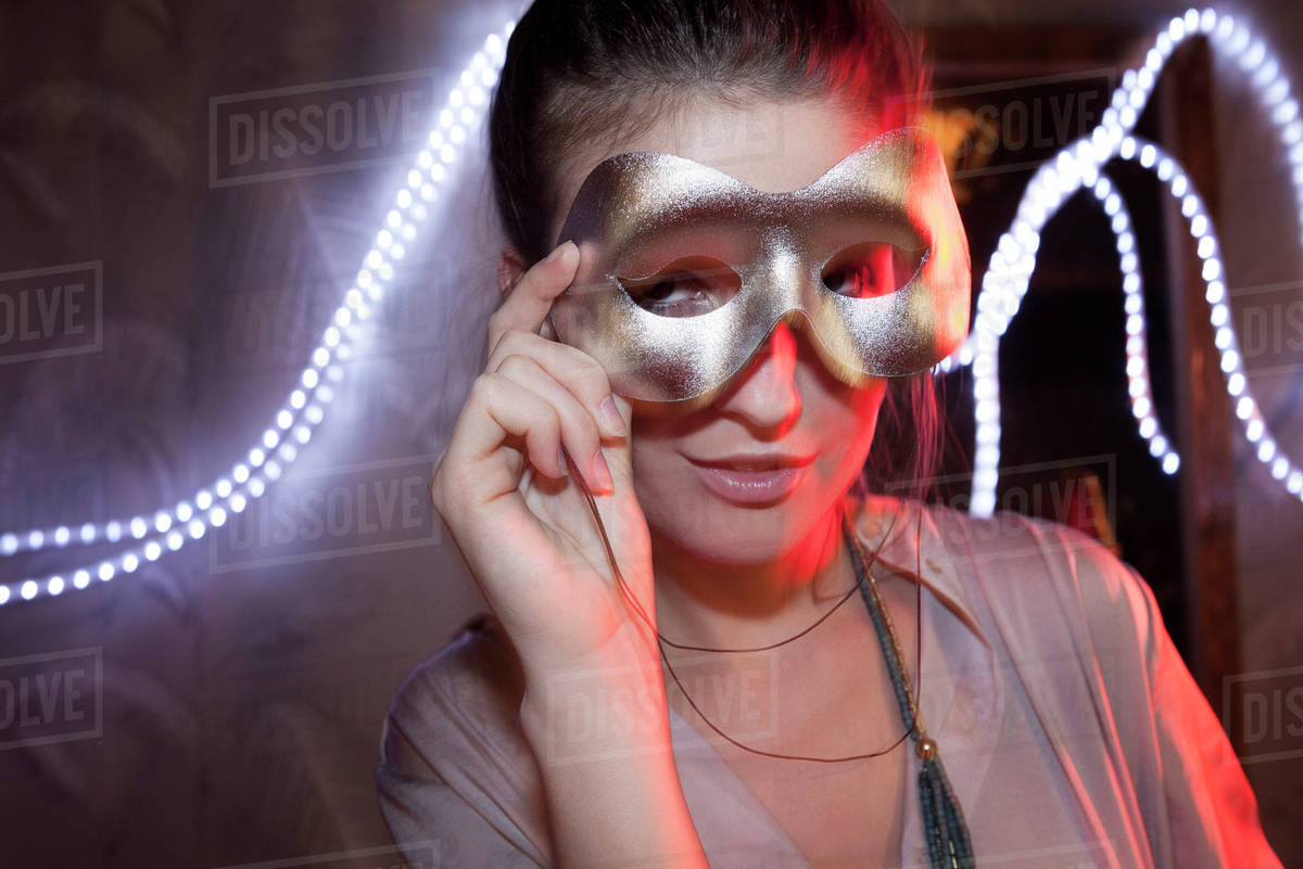 Woman holding party mask in front of face, portrait - Royalty-free ...