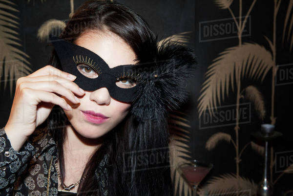 Woman wearing party mask, portrait - Stock Photo - Dissolve
