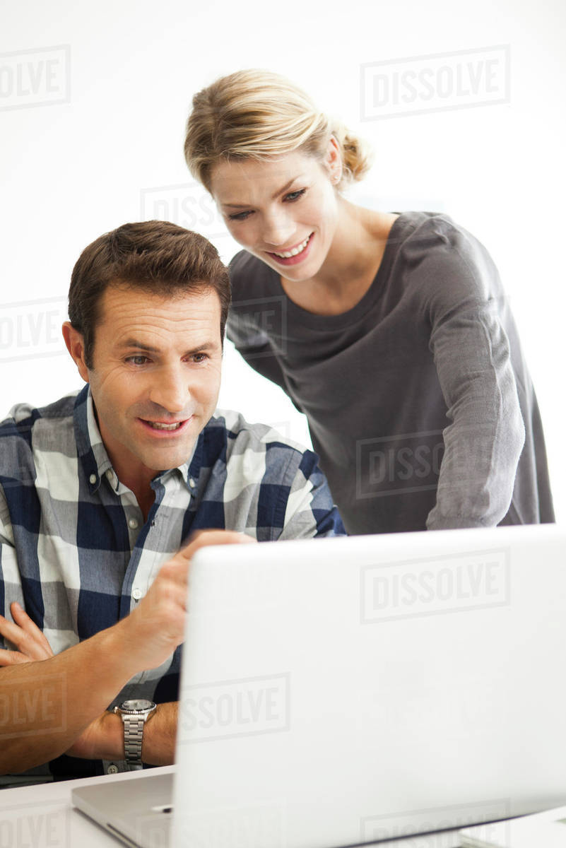 Colleagues looking at laptop computer together - Royalty-free Stock ...