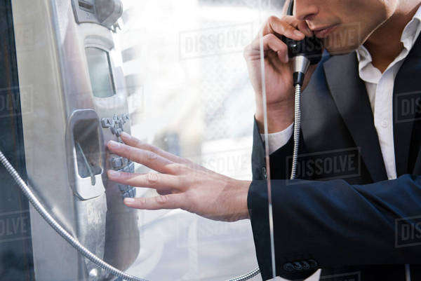 Man using pay phone - Stock Photo - Dissolve
