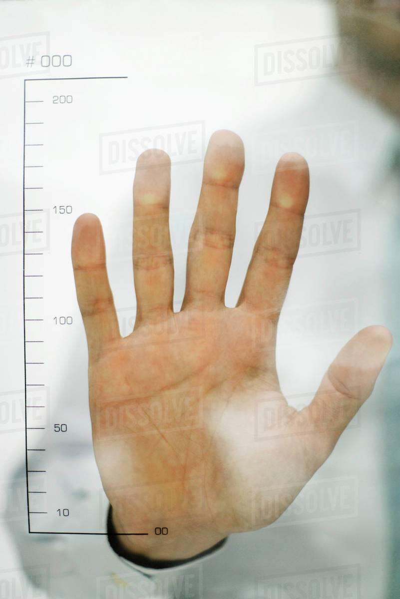 Man holding hand up to ruler - Royalty-free Stock Photo | Dissolve