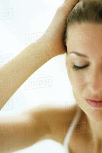 Woman pulling hair back, eyes closed - Royalty-free Stock Photo | Dissolve