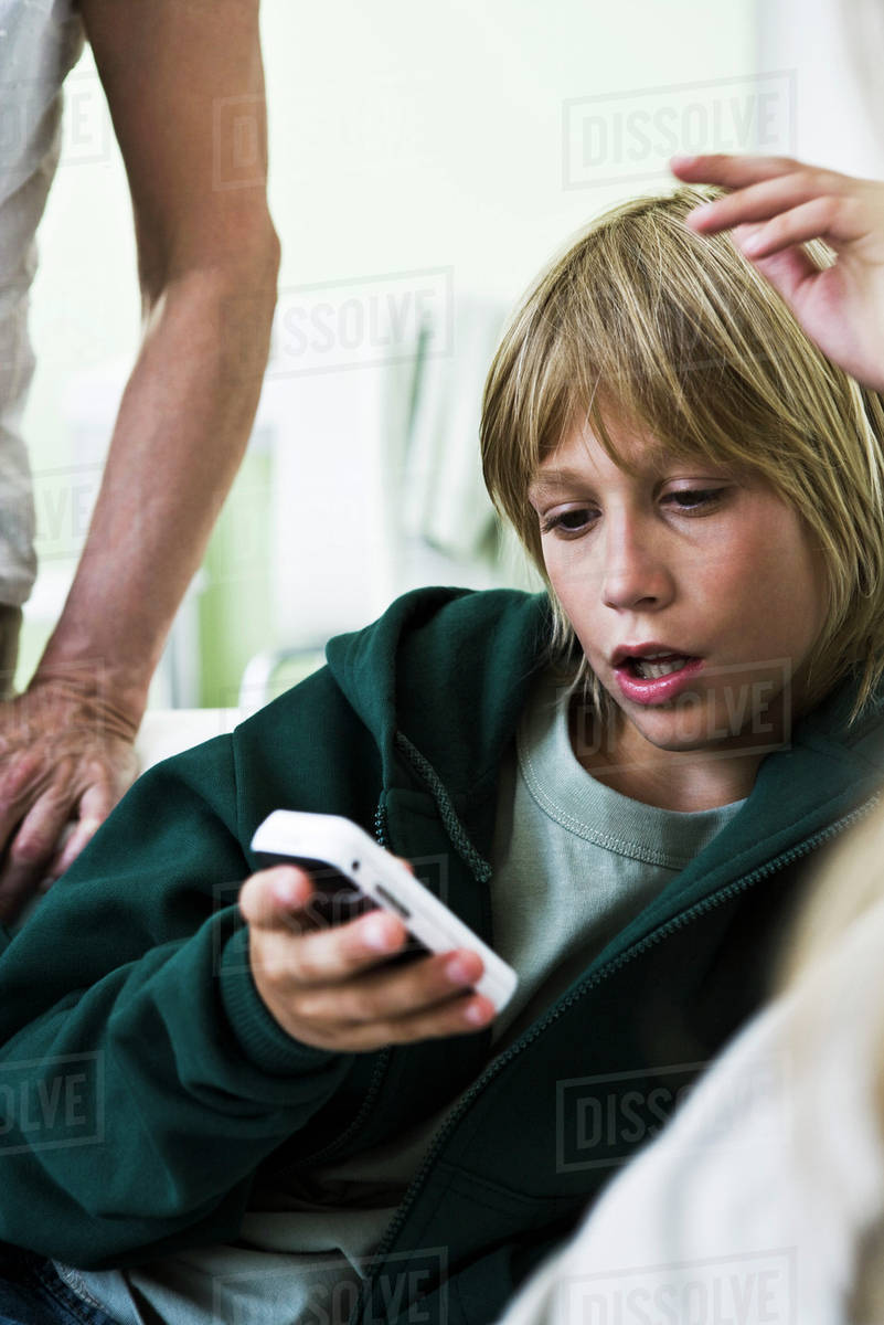 Boy looking at cell phone - Royalty-free Stock Photo | Dissolve
