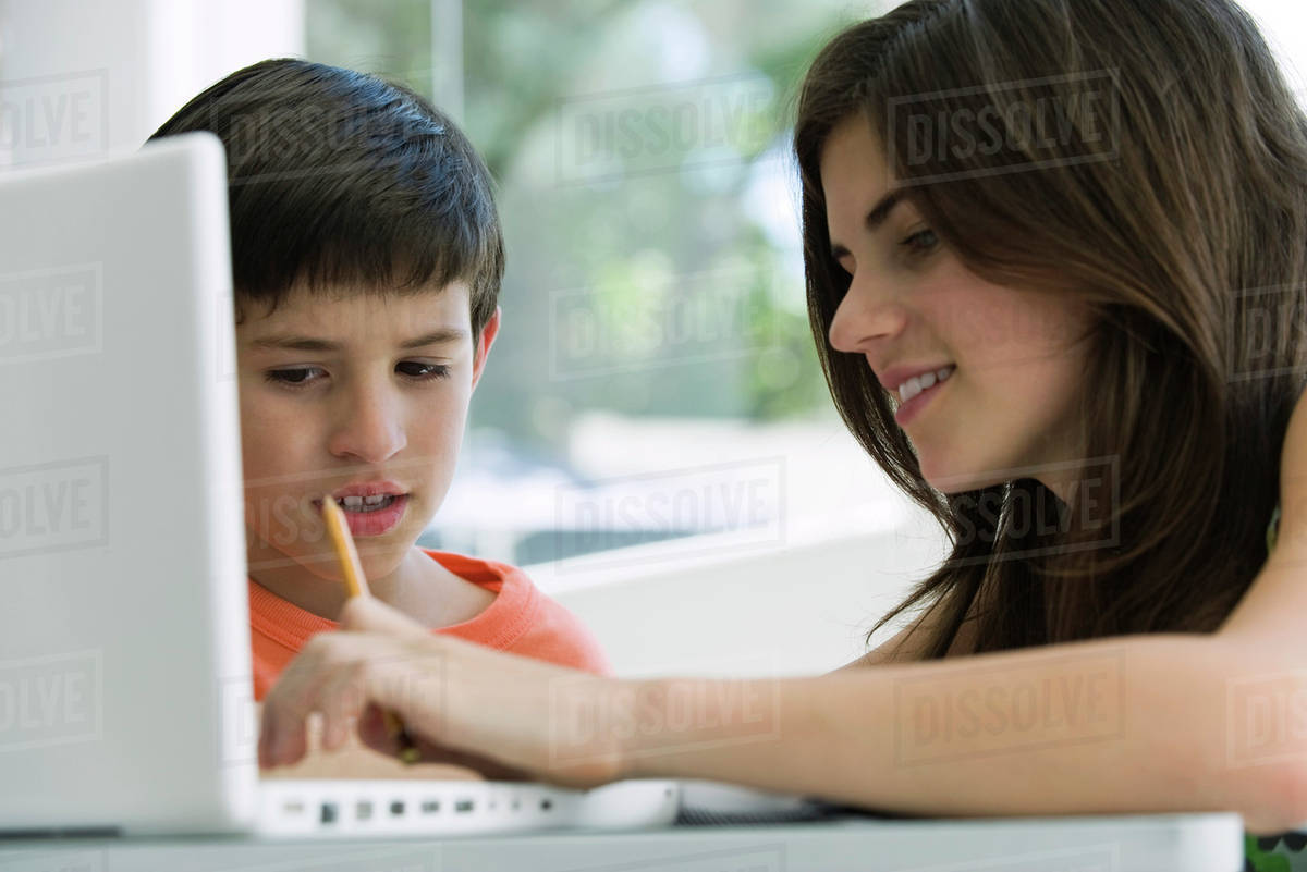 Little boy watching older sister use laptop computer - Royalty-free ...