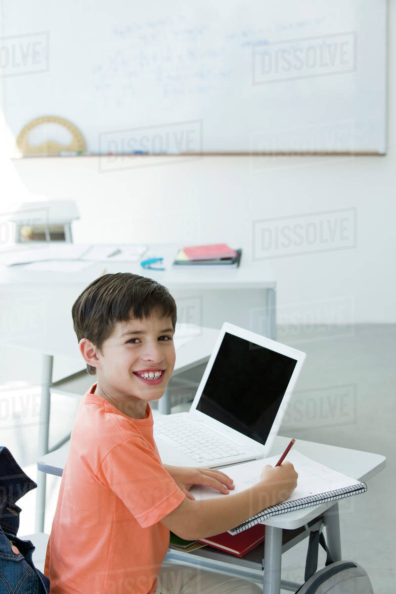Elementary school student doing classwork, smiling at camera - Royalty ...