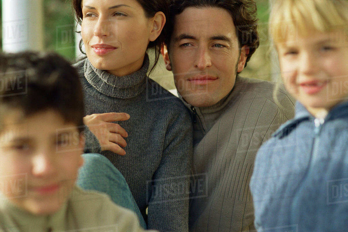Parents looking away, smiling, children in foreground - Stock Photo ...