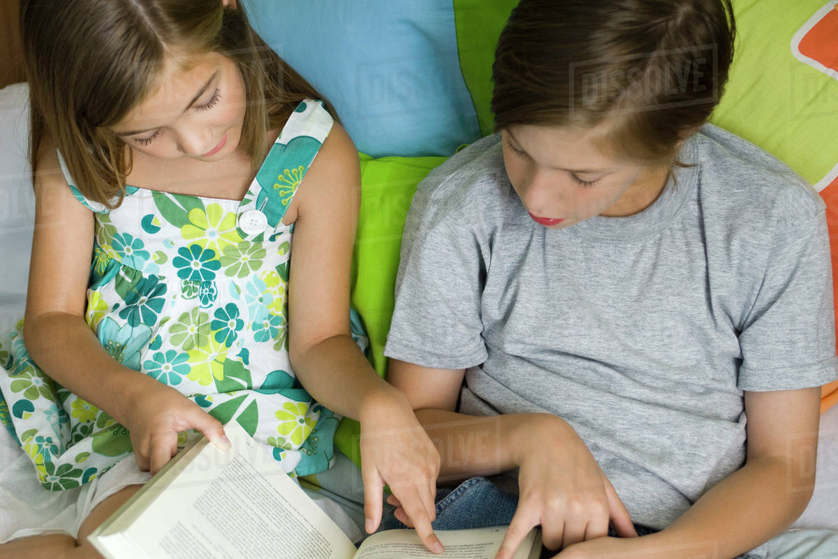 Siblings reading together - Royalty-free Stock Photo | Dissolve