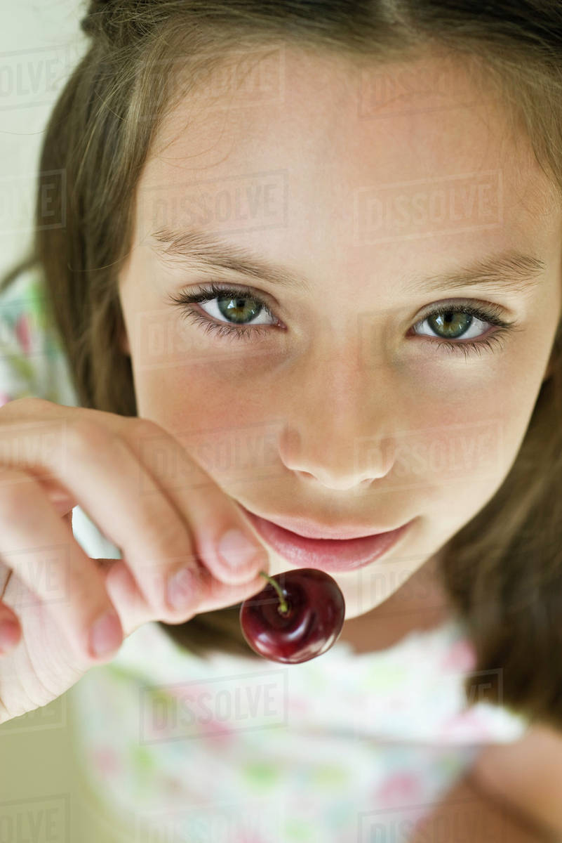 Girl eating cherry - Royalty-free Stock Photo | Dissolve