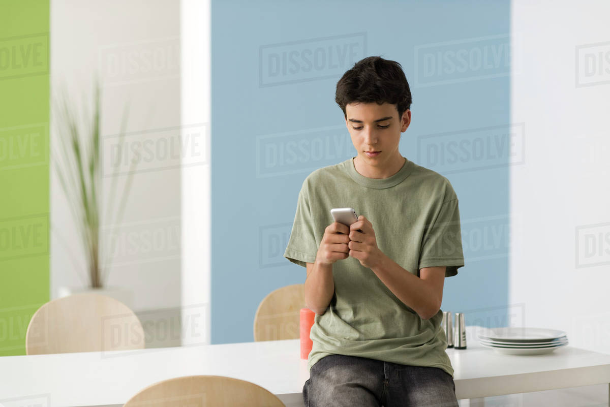 Teenage boy text messaging - Stock Photo - Dissolve