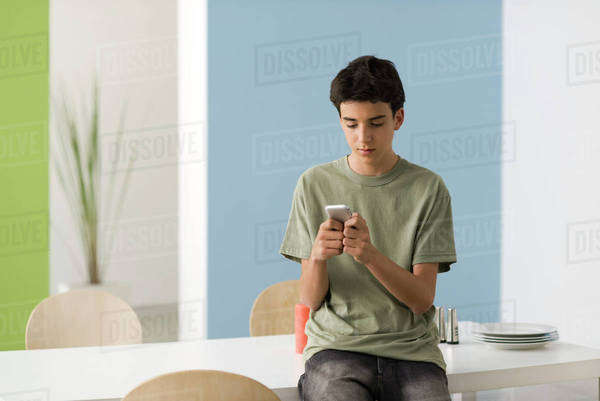 Teenage boy text messaging - Stock Photo - Dissolve