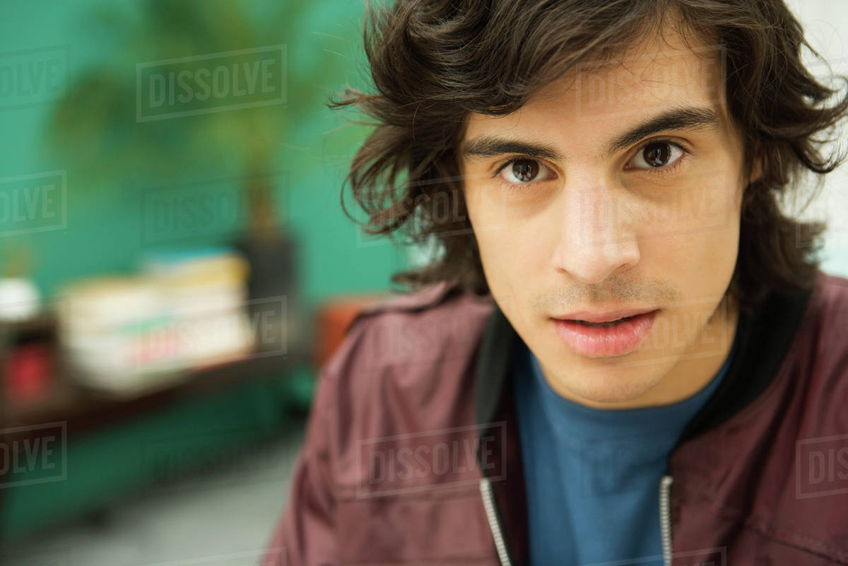 Young man staring at camera, portrait - Stock Photo - Dissolve