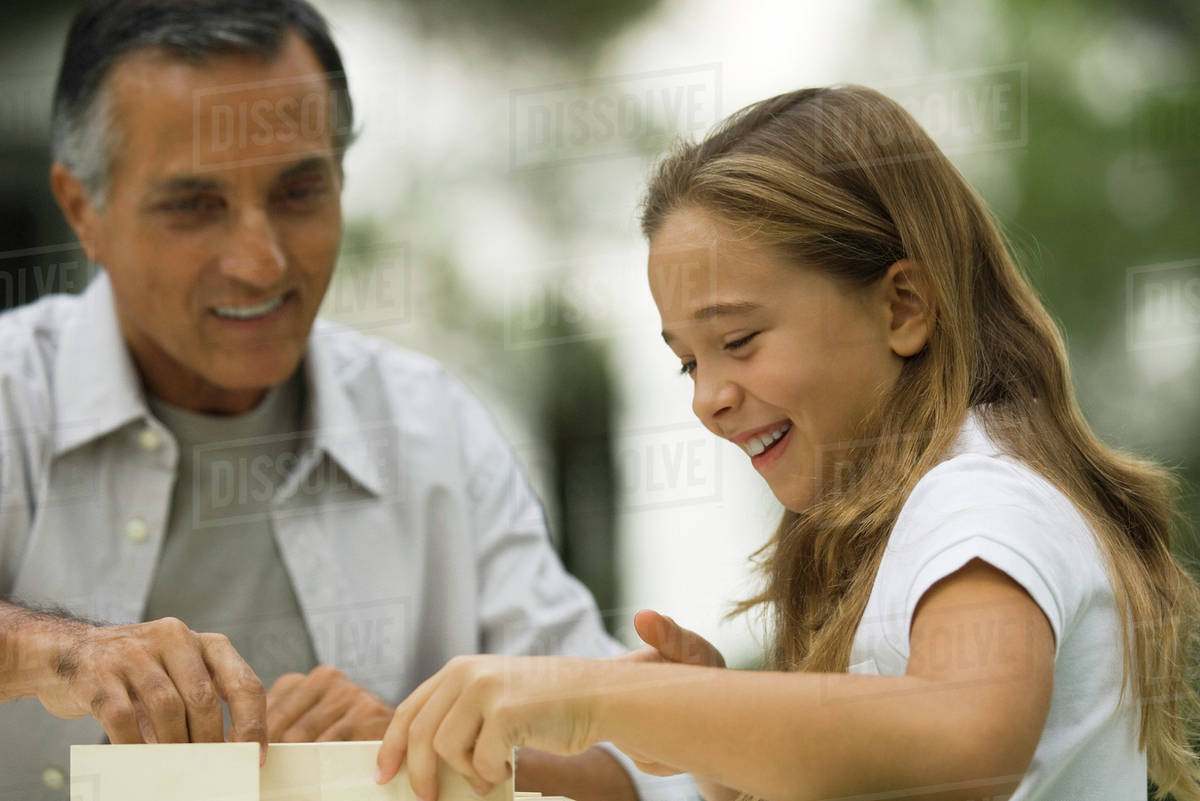 Father watching as young daughter opens gift - Royalty-free Stock Photo ...