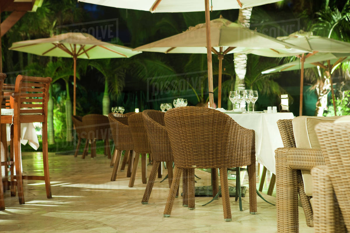 Illuminated outdoor cafe at night, surrounded by palm trees - Royalty ...