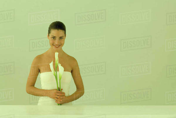 Young woman holding calla lilies, smiling at camera - Royalty-free ...
