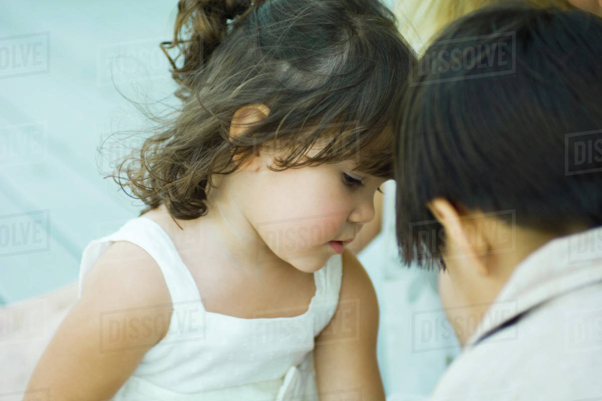 Two children face to face, looking down, cropped view - Stock Photo ...
