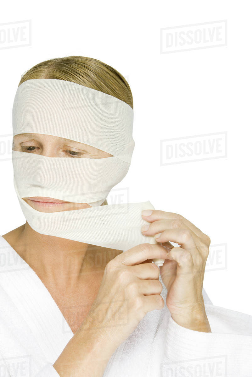 Woman removing bandages from face, looking away - Royalty-free Stock ...