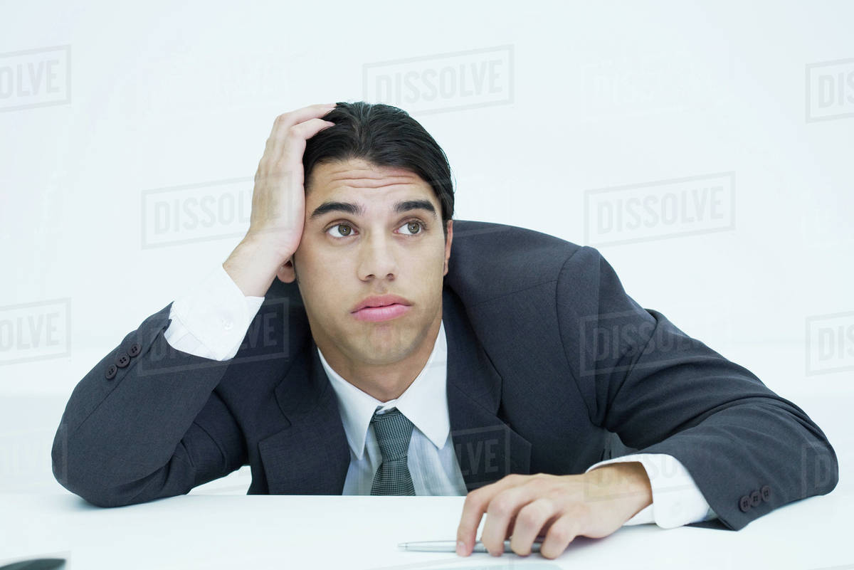 Young businessman slouching on desk, holding head - Royalty-free Stock ...