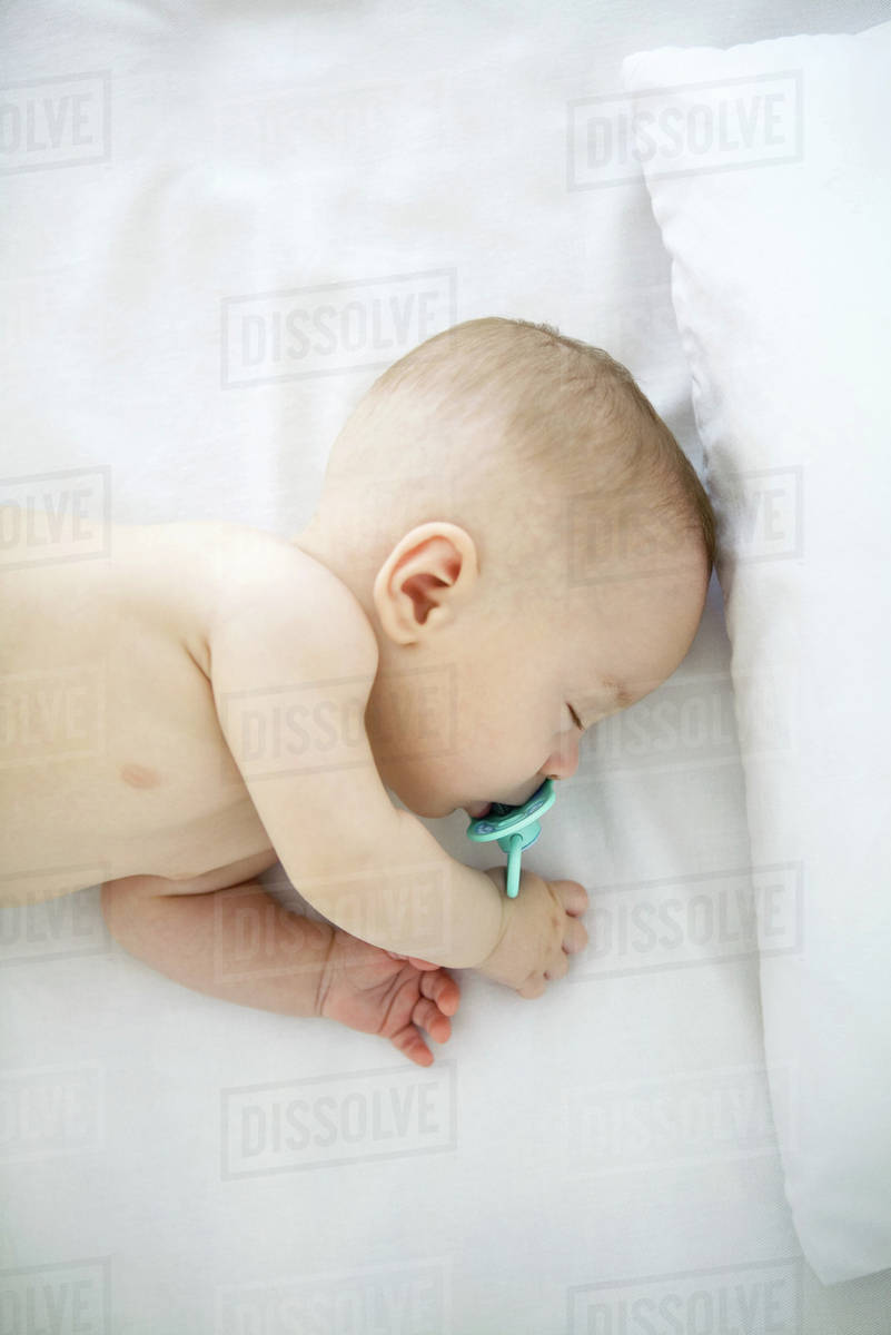 Infant napping, pacifier in mouth, high angle view - Royalty-free Stock ...